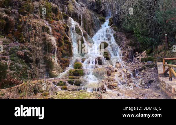 A breathtaking waterfall cascades over rocks, surrounded by lush ...