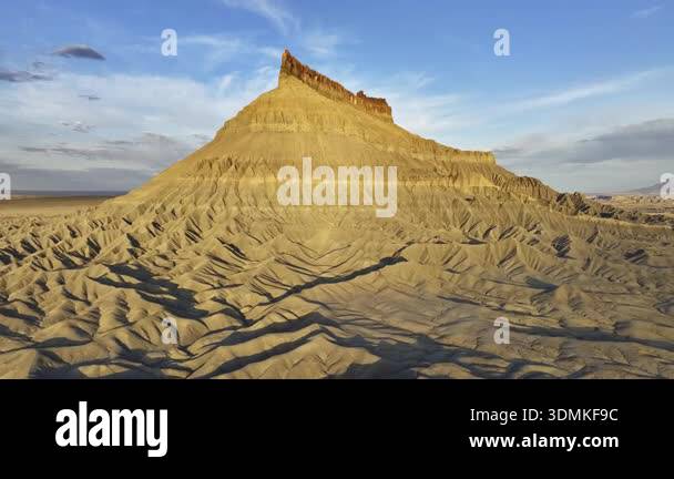 Factory Butte in Utah stands prominently against a clear blue sky ...