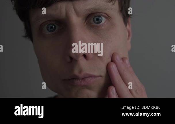 Man noticing single pimple on his face, examining skin in mirror, acne ...