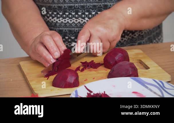 Chopping beetroot into thin slices for cooking Ukrainian borscht ...
