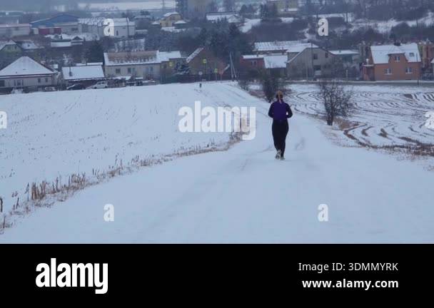 Solo Runner On Snowy Rural Road, Wearing Purple Jacket, Jogging Toward ...