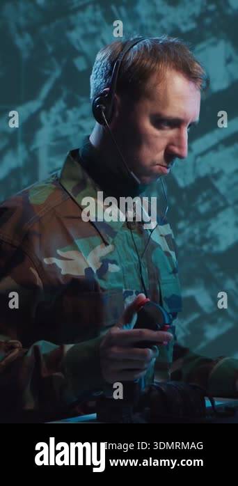 Soldier in a dimly lit military control room, intensely focused on ...