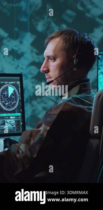 Soldier in a dimly lit military control room, intensely focused on ...
