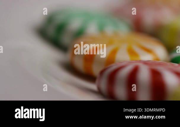 macro rack focus shot along row of colorful striped peppermint hard ...