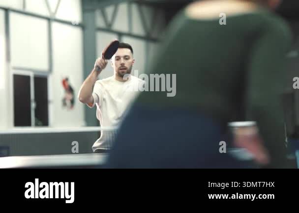 Caucasian man concentrating while playing a competitive game of ping ...