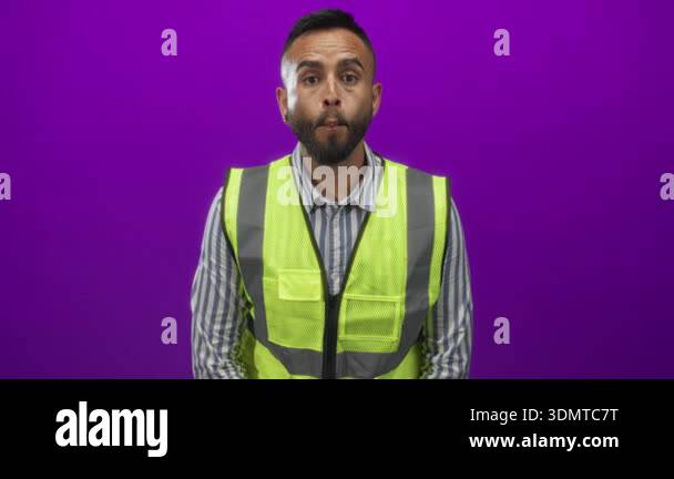 Man wearing reflective safety vest and striped shirt, pursing lips ...