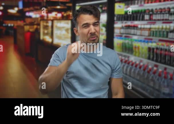 Young man making mocking expression indoors in restaurant with beverage ...