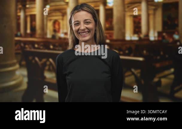 Woman smiling with puckered lips and warm expression inside a historic ...