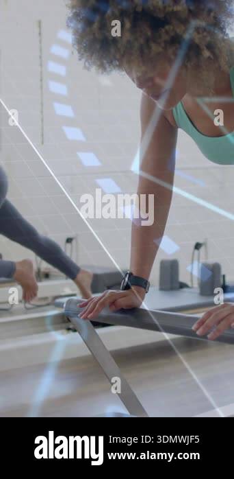 Women exercising on reformer machines with digital data overlay ...