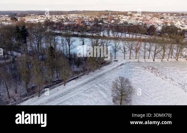Snowy rural landscape with open fields scattered leafless trees and ...