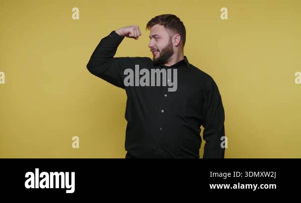 A man raises his arm to show strength while standing in front of a ...