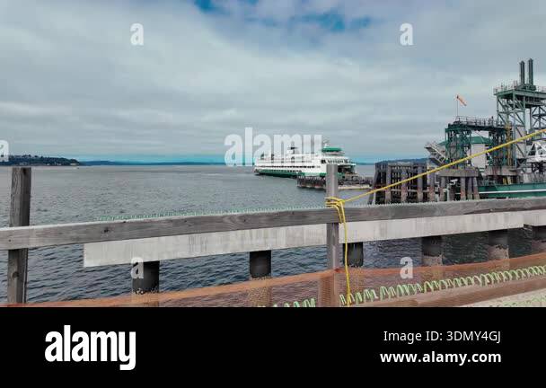 Ferry departing industrial dock with steel loading structure over ...