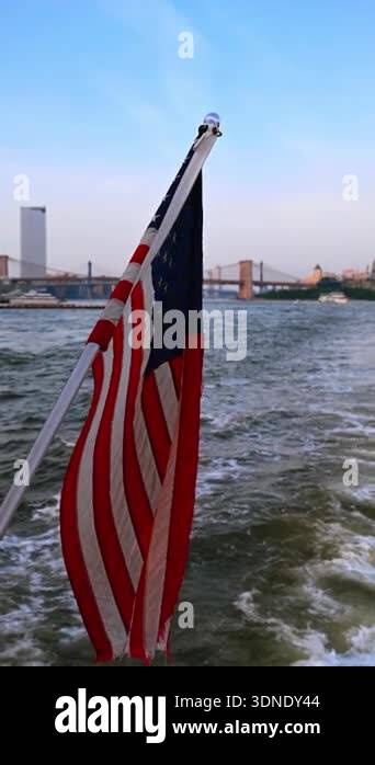American flag over river wake and bridges. American flag on a ferry ...
