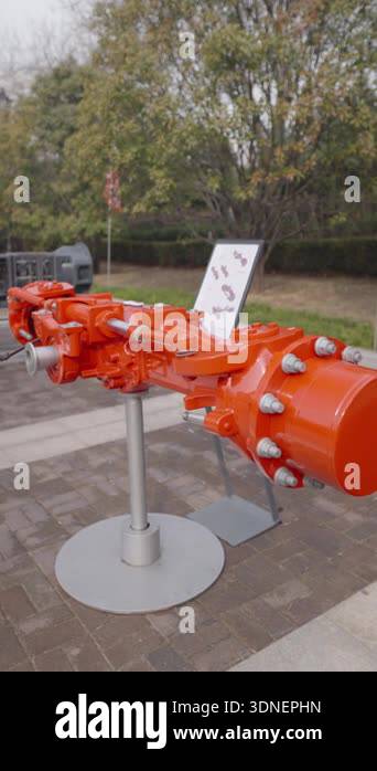 Large red metal agricultural machinery component displayed on stand at ...