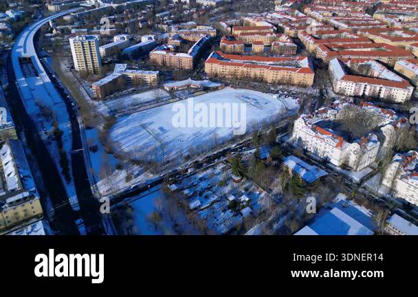 Berlin cityscape with a snow-covered football field, residential ...