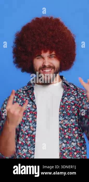 Overjoyed happy Caucasian man showing rock n roll gesture by hands ...