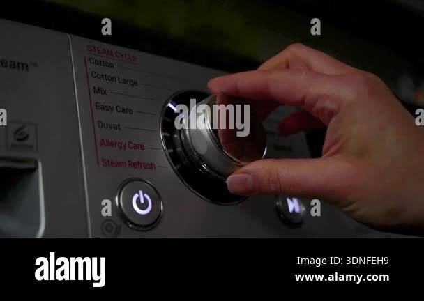 Smart home appliances. Adjusting washing machine setting. Hand turning ...