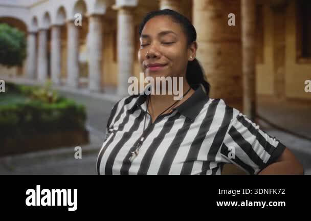 Confident African American woman referee wearing black and white ...