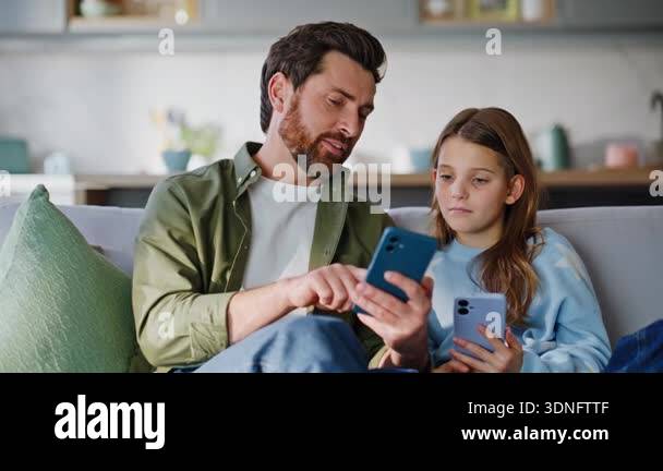 Father teenager looking mobile phones scrolling news feed at living ...