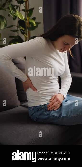 Suffer young woman painful with back pain, back ache sitting on sofa at ...