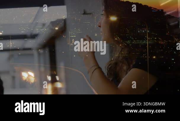 Photographer raising camera to capture woman by window while city-light ...