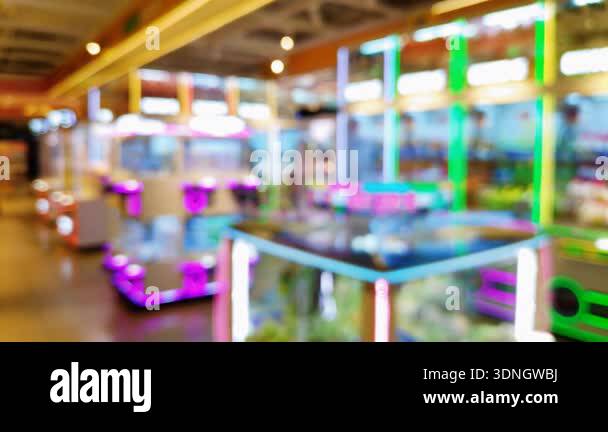 Blurred background of a crowded arcade featuring vibrant claw machines ...