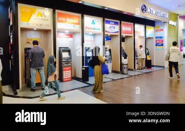 Peopl use ATM machines to get money while visiting a busy shopping ...