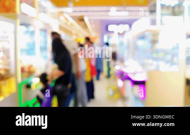 Blurred background of a crowded arcade featuring vibrant claw machines ...