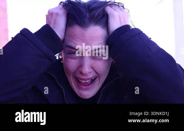 Woman crying and screaming, clutching head in despair, representing ...
