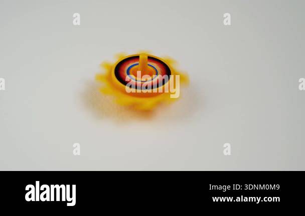 Colorful Yellow Plastic Spinning Top Toy Rotating Fast on White ...