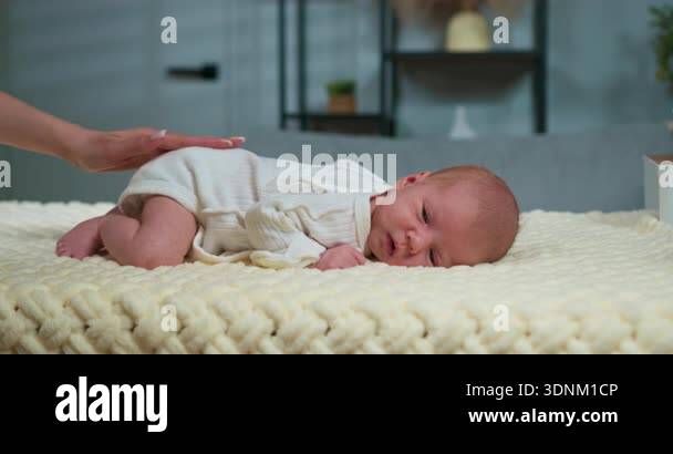 Parents hand caressing newborn babys head, promoting comfort and ...