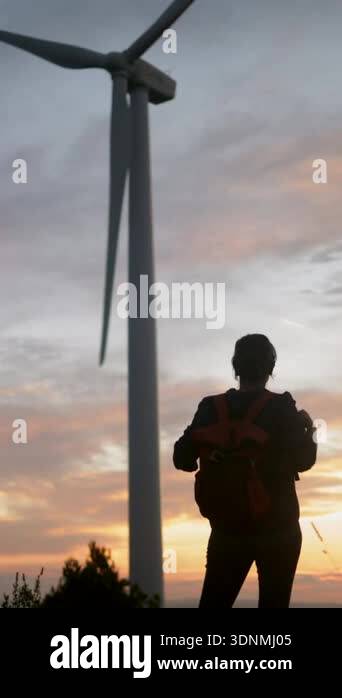 female Person standing near wind turbine at sunset Stock Video Footage ...