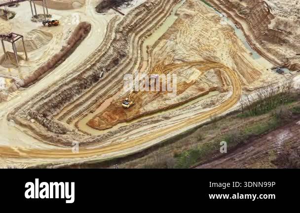 Heavy machinery works on a construction site, moving earth and shaping ...