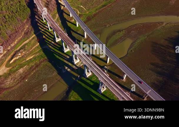 A highway and a railway bridge cross over a river. Vehicles are moving ...