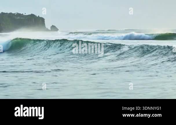 Cinematic fly-by around a powerful ocean wave in slow motion, capturing ...