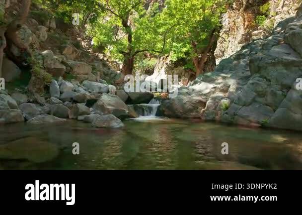 Aerial view of a stunning waterfall cascading into crystal clear ...