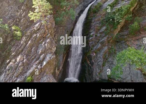 Aerial view of a stunning waterfall cascading into crystal clear ...