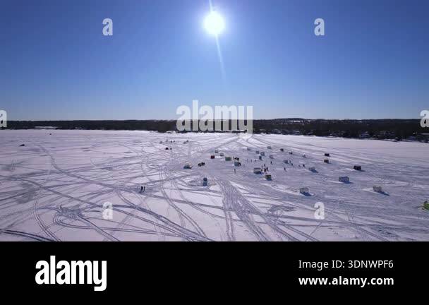 Snowmobile ski fresh tracks and fishing huts on frozen Lake Simcoe ...