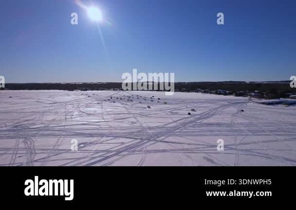 Aerial fly over intricate pattern of snowmobile race track on a frozen ...