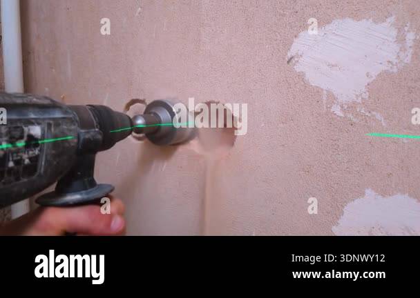 Professional worker using a powerful hammer drill with a core bit to ...