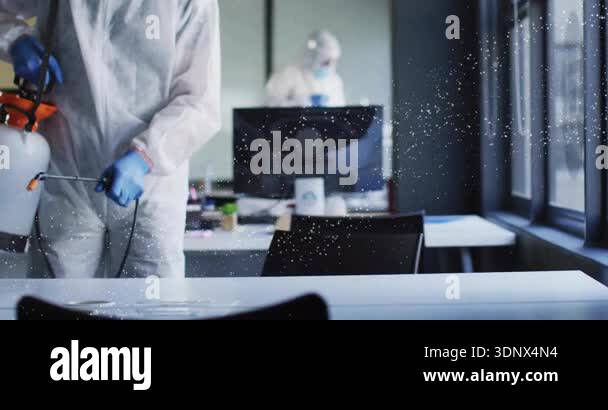 Sanitation technician activating nozzle and misting disinfectant across ...