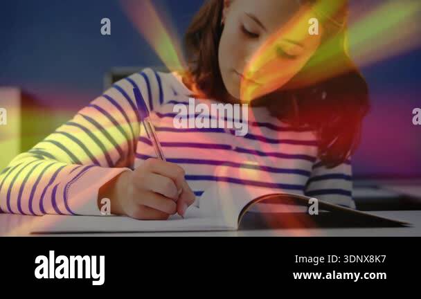 Female student picking pencil and writing on notebook on desk in class ...