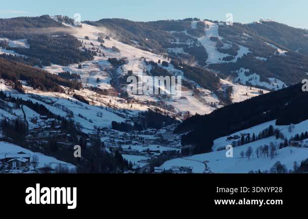 Aerial shot of Saalbach ski resort with slopes and snowy valley in ...