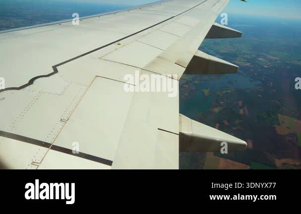 Jet flying above lake and farmland with visible wing and flap fairings ...