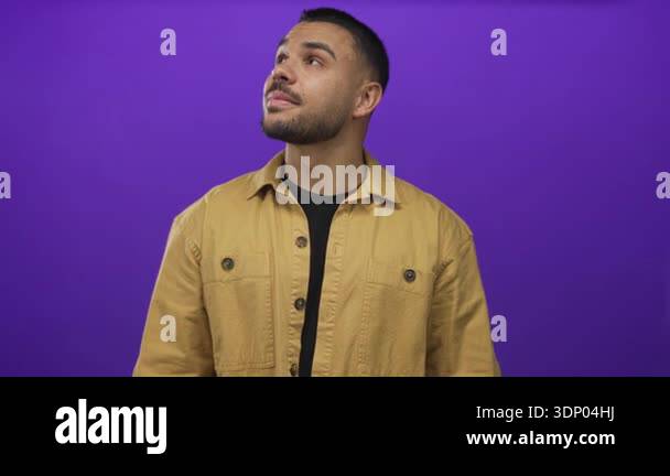 Man face looking up in purple studio setting wearing brown jacket with ...