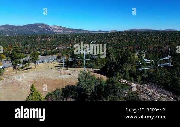 Aerial drone footage shows an empty ski lift running across dry ...