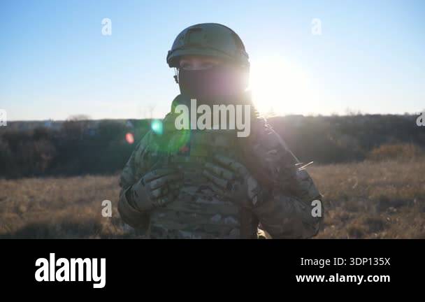 Young female military medic walking at field on sunny day. Ukrainian ...
