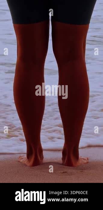Vertical video. Legs Standing in Incoming Foamy Surf on Sandy Shore in ...