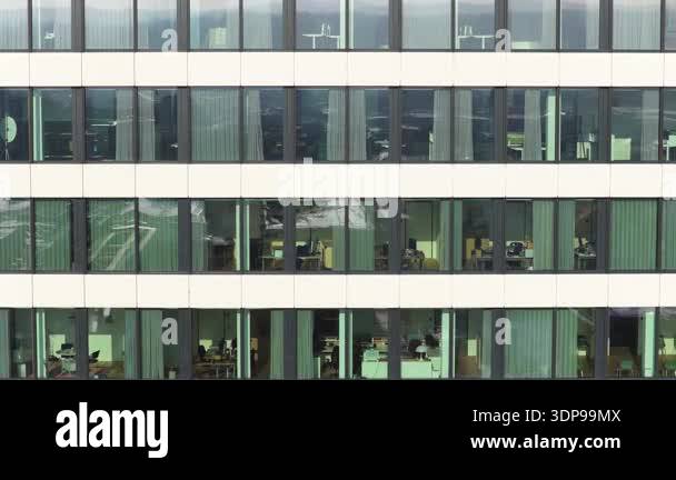 Aerial shot moving up along facade of a modern office building ...