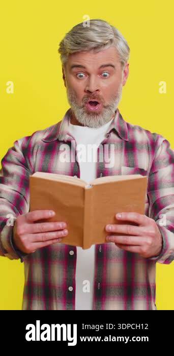 Mature man opens book with eager hope, showing bright surprise and ...